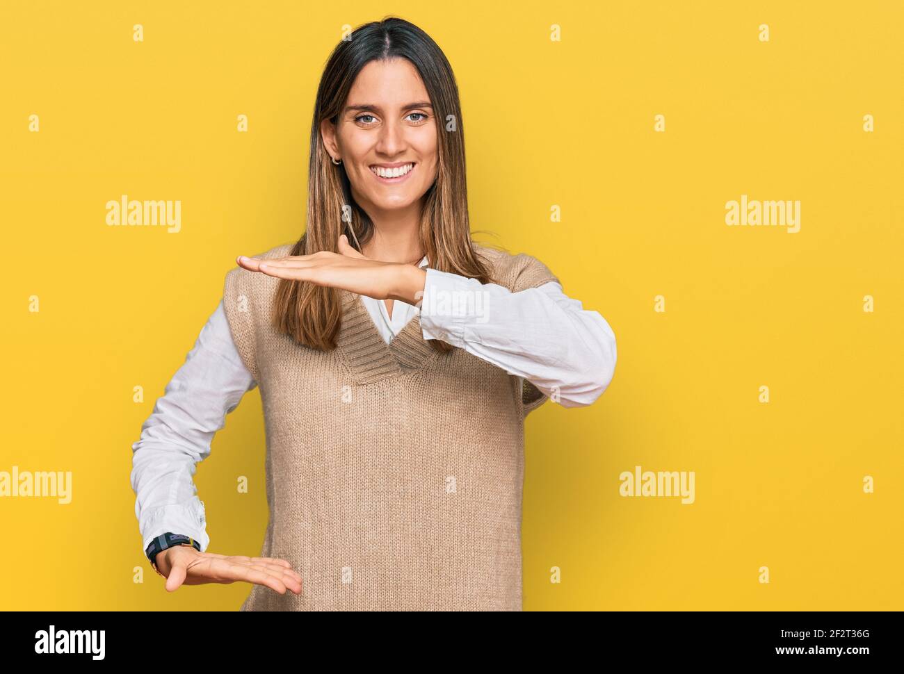 Young woman wearing casual clothes gesturing with hands showing big and ...