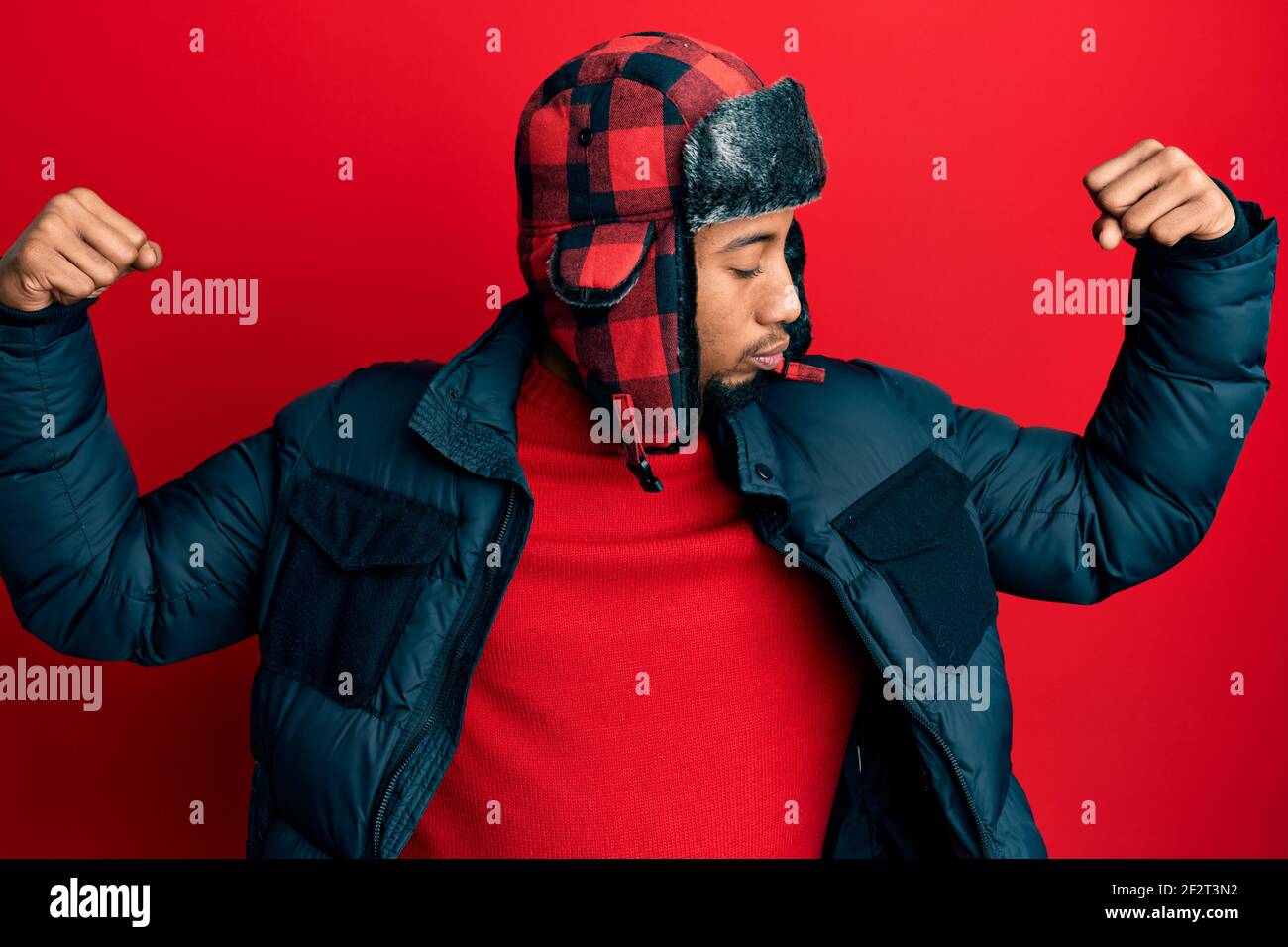Young african american man with beard wearing winter hat and coat ...
