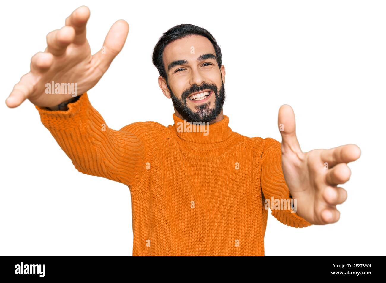 Young hispanic man wearing casual clothes looking at the camera smiling ...
