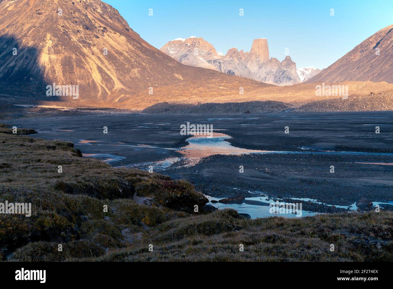 Wild river winds through remote, stony arctic landscape. A big moraine ...