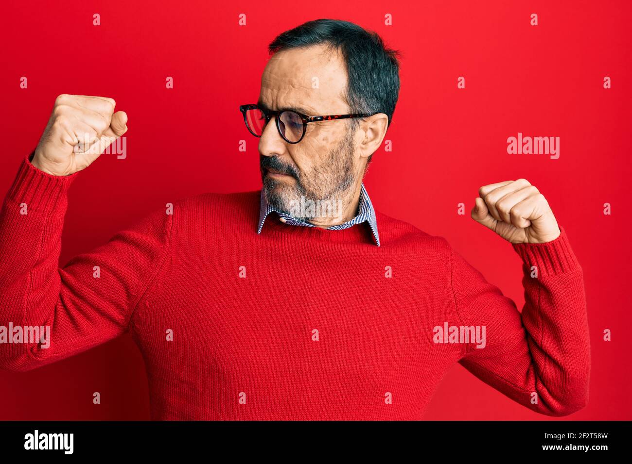 Middle age hispanic man wearing casual clothes and glasses showing arms ...