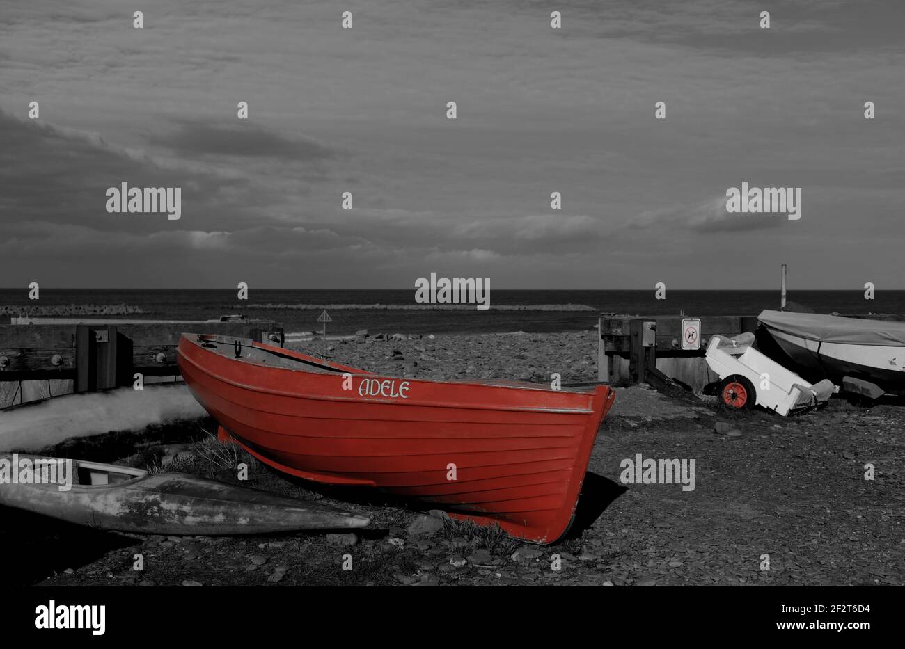 Adele: red, wooden boat at Borth, Ceredigion, Wales. A black and white ...