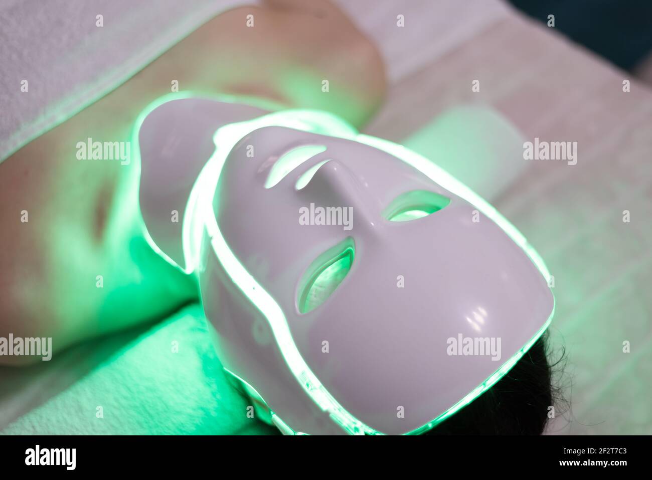 LED mask regenerative treatment applied to a young woman. Woman with ...