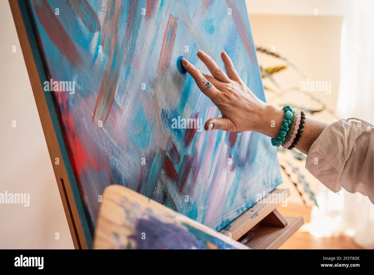 Abstract art paintings in studio. Woman artist painting on canvas by ...