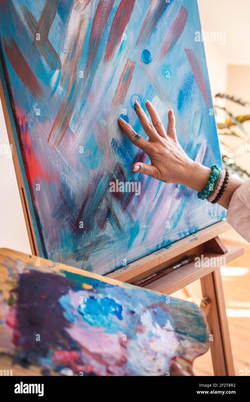 Abstract art paintings. Woman artist painting on canvas by hand and ...
