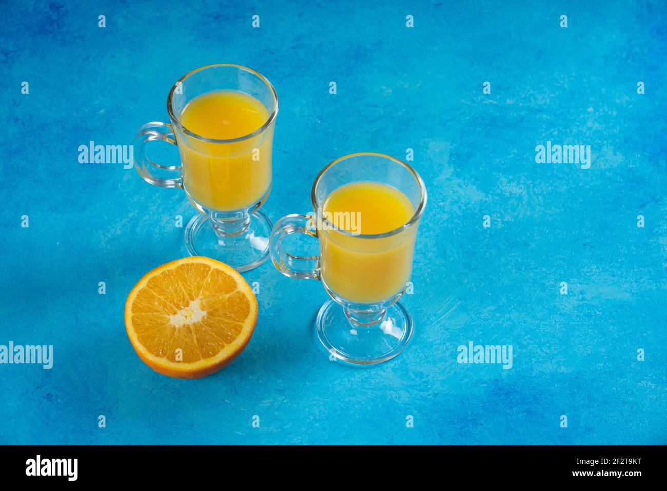 Two glass cups of juice with slice of orange Stock Photo - Alamy