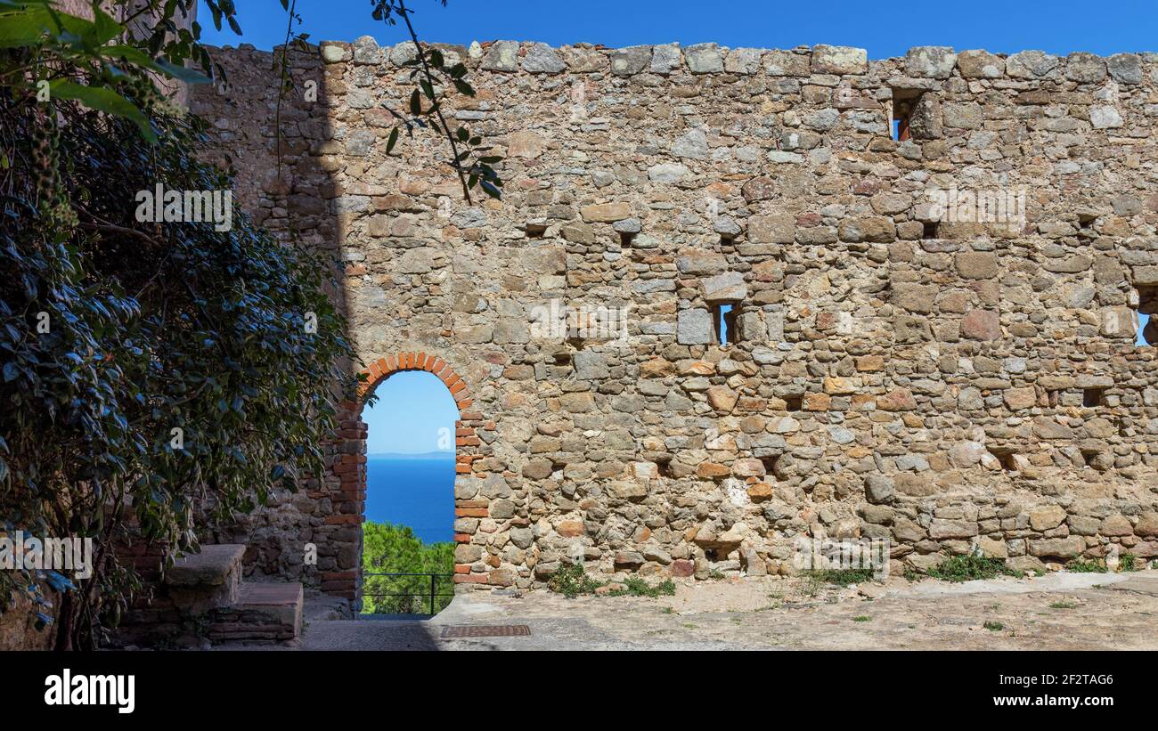 View through the arch. Arch overlooking the sea in the medieval wall on ...