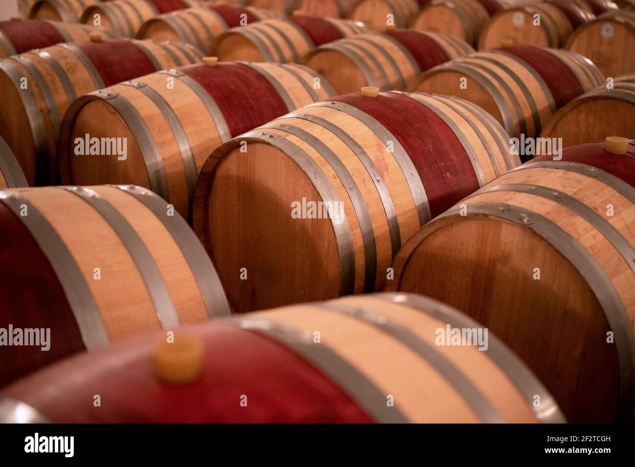 Wine barrels stacked in the old cellar of the winery. (Selective focus ...