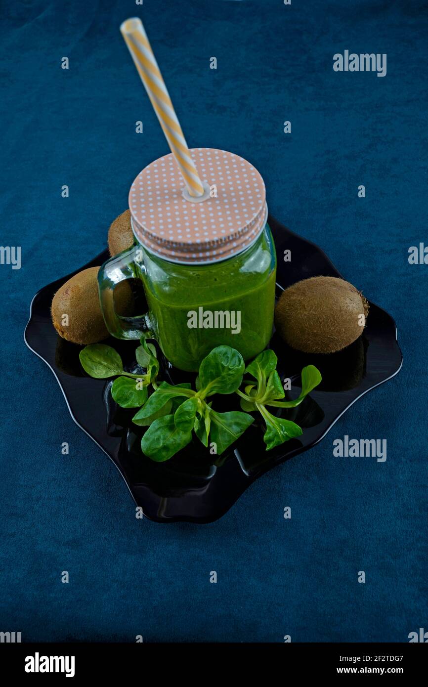 Leaf saladand kiwi smoothie on a black plate and decorated with kiwi ...