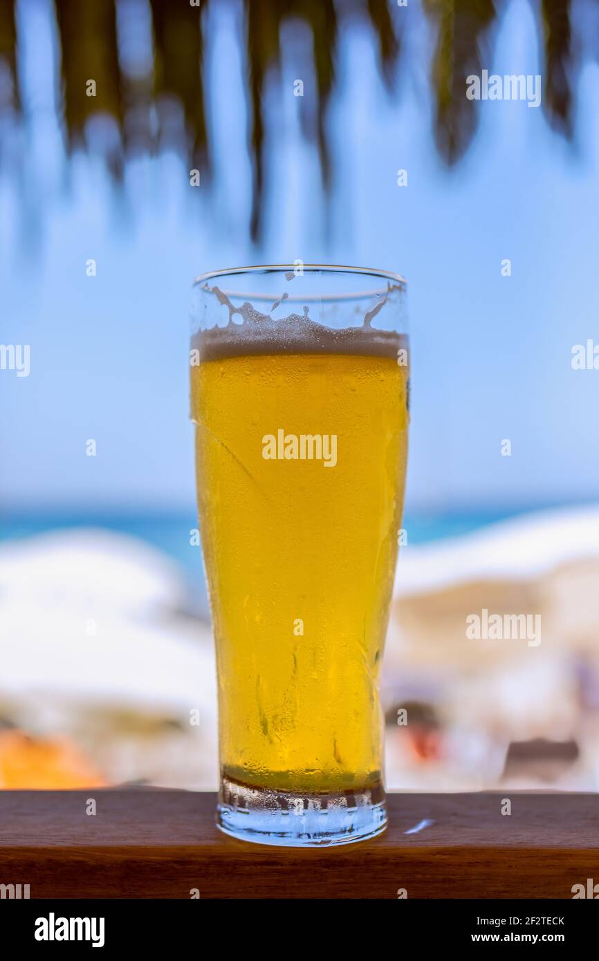 Glass of cold beer at a beach bar (Vertical Photo Stock Photo - Alamy