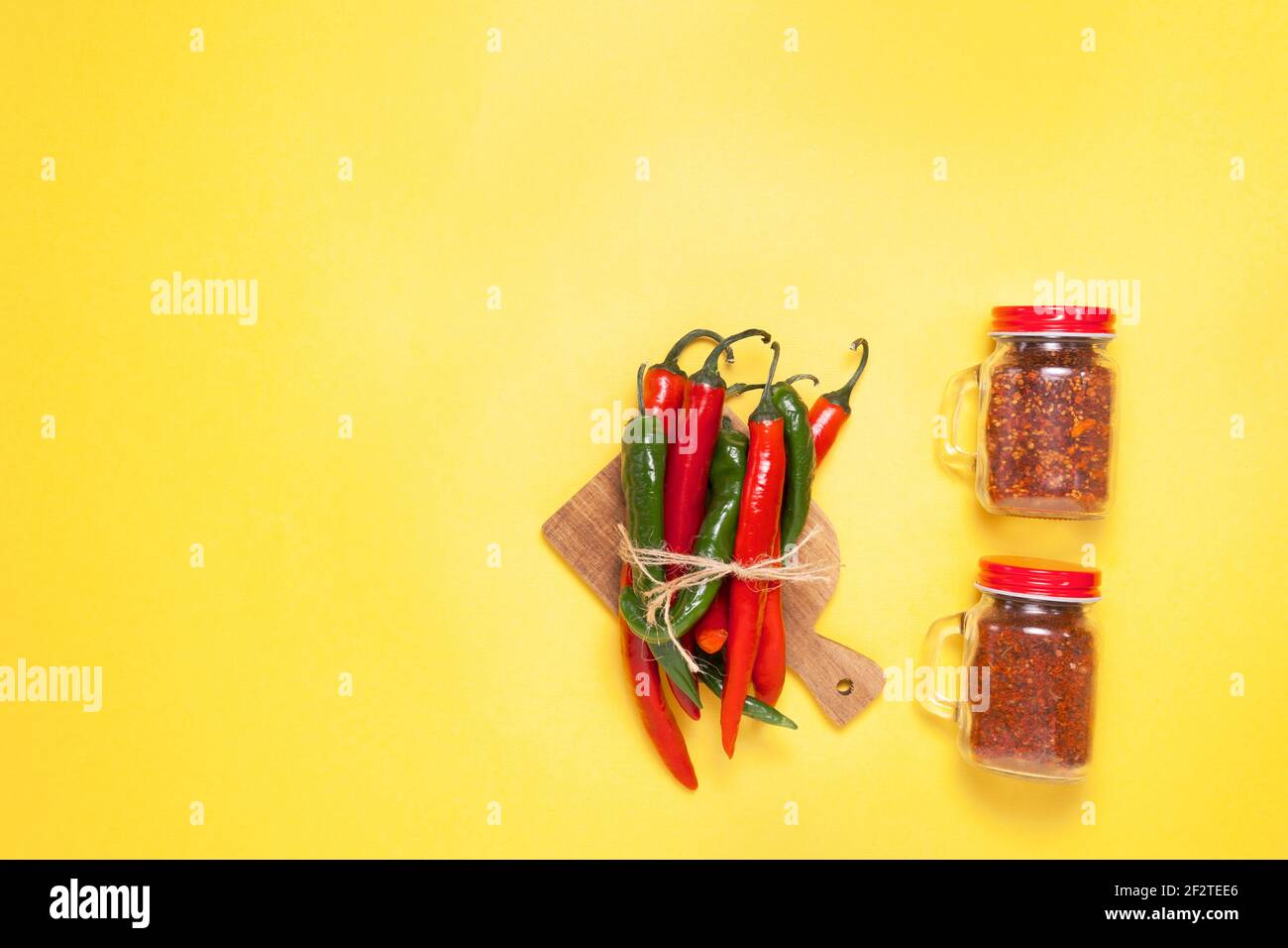 Red green hot chili peppers on yellow background Flat lay. spices dry ...