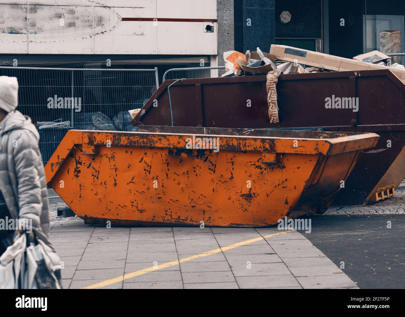 Waste and recycling orange skip next to construction site in the city ...