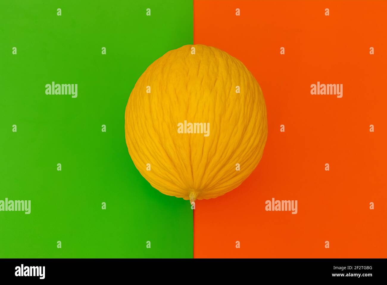 Yellow melon on a two-tone orange and green background. Food concept ...