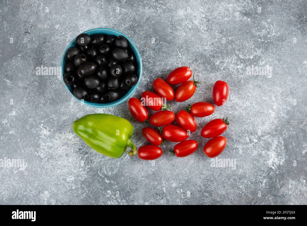 Black olives, pepper and tomatoes on marble background Stock Photo - Alamy