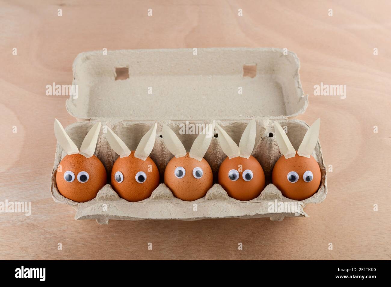 Easter eggs with eyes and rabbit ears in an egg container. Happy Easter ...