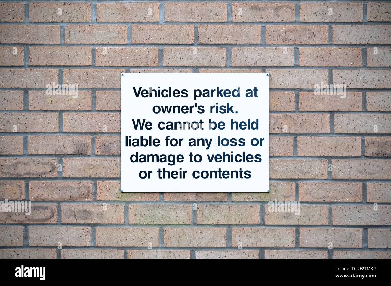 Car park users do so at own risk sign Stock Photo - Alamy