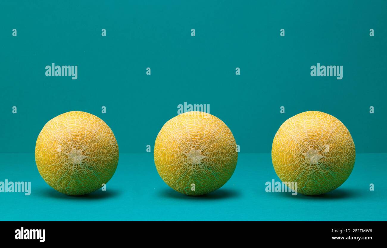 three fresh whole ripe melons on turquoise color background Stock Photo ...