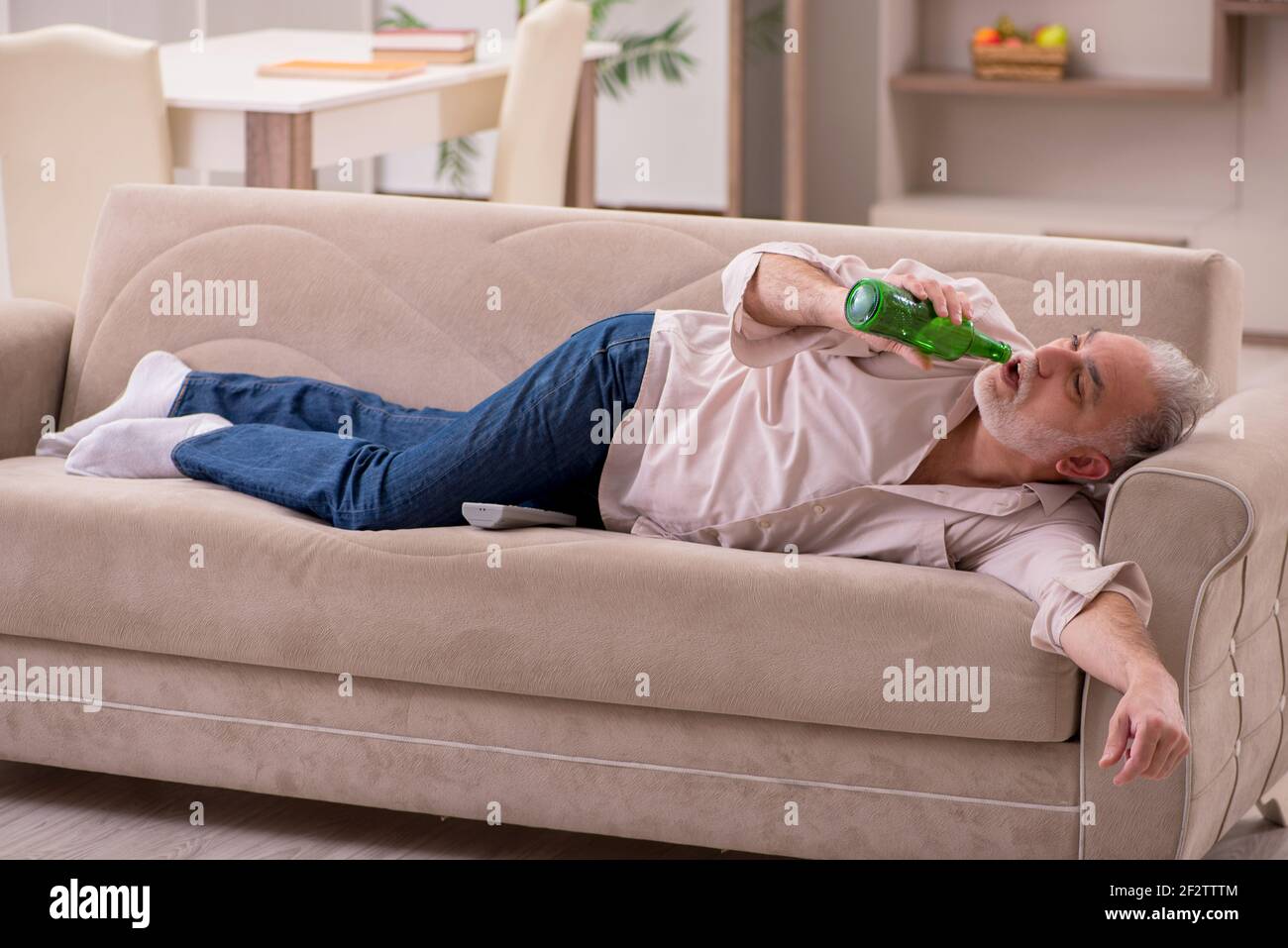 Aged man drinking alcohol at home Stock Photo - Alamy
