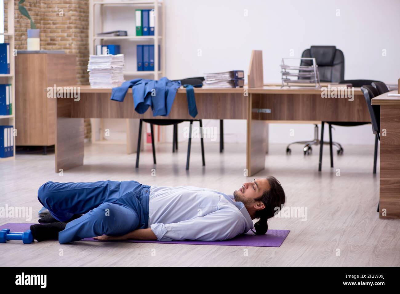 Young employee doing sport exercises during break Stock Photo - Alamy