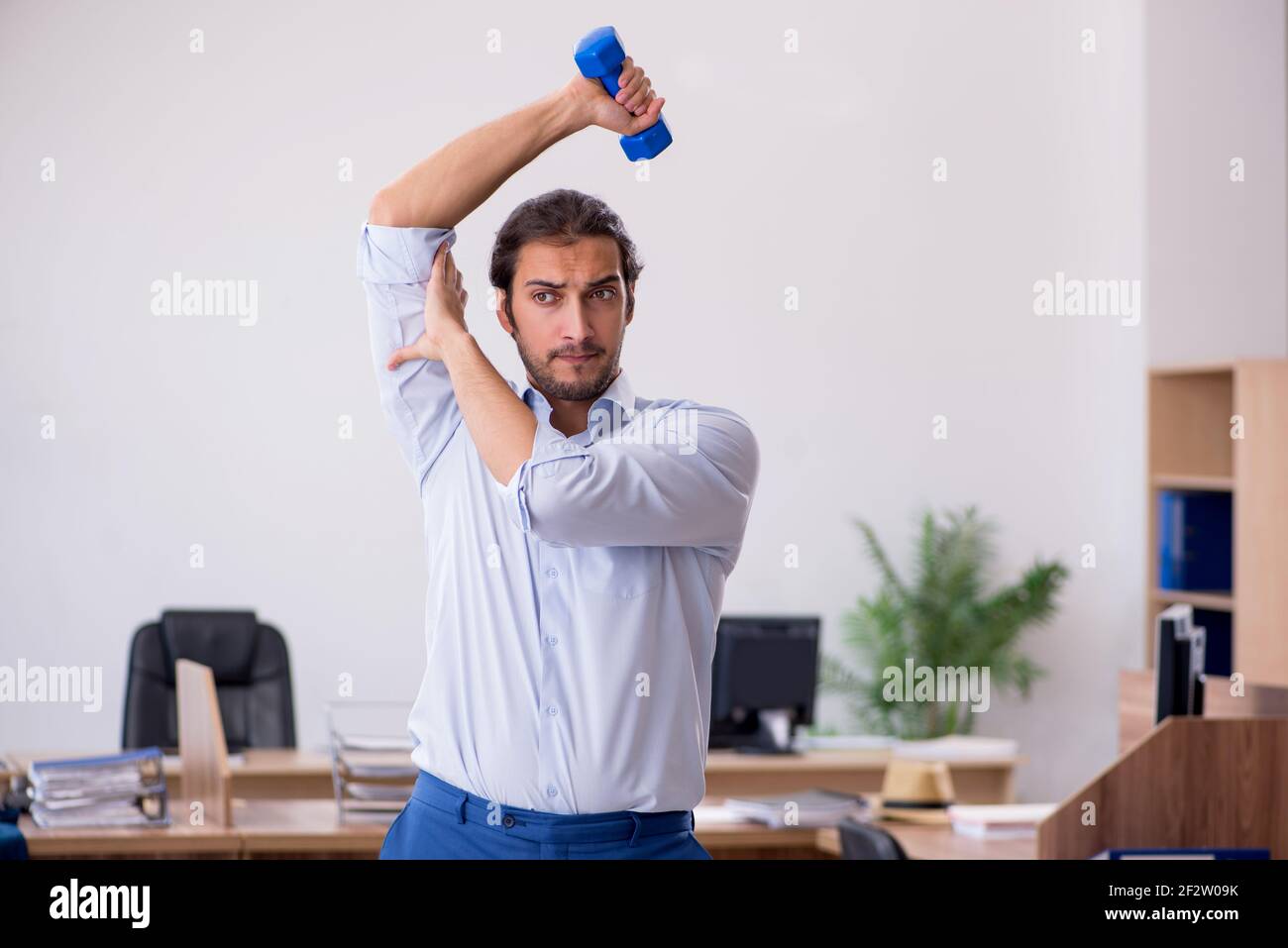 Young employee doing sport exercises during break Stock Photo - Alamy