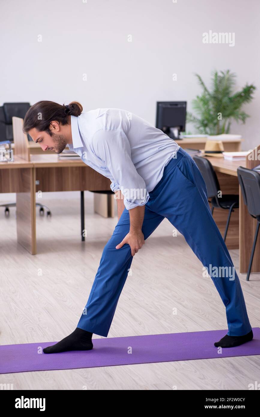 Young employee doing sport exercises during break Stock Photo - Alamy