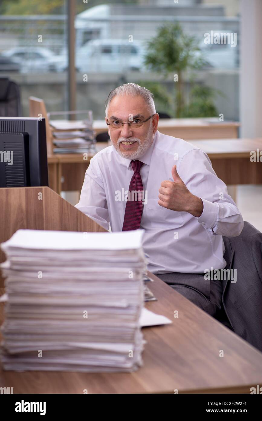 Old male employee and too much work in the office Stock Photo - Alamy