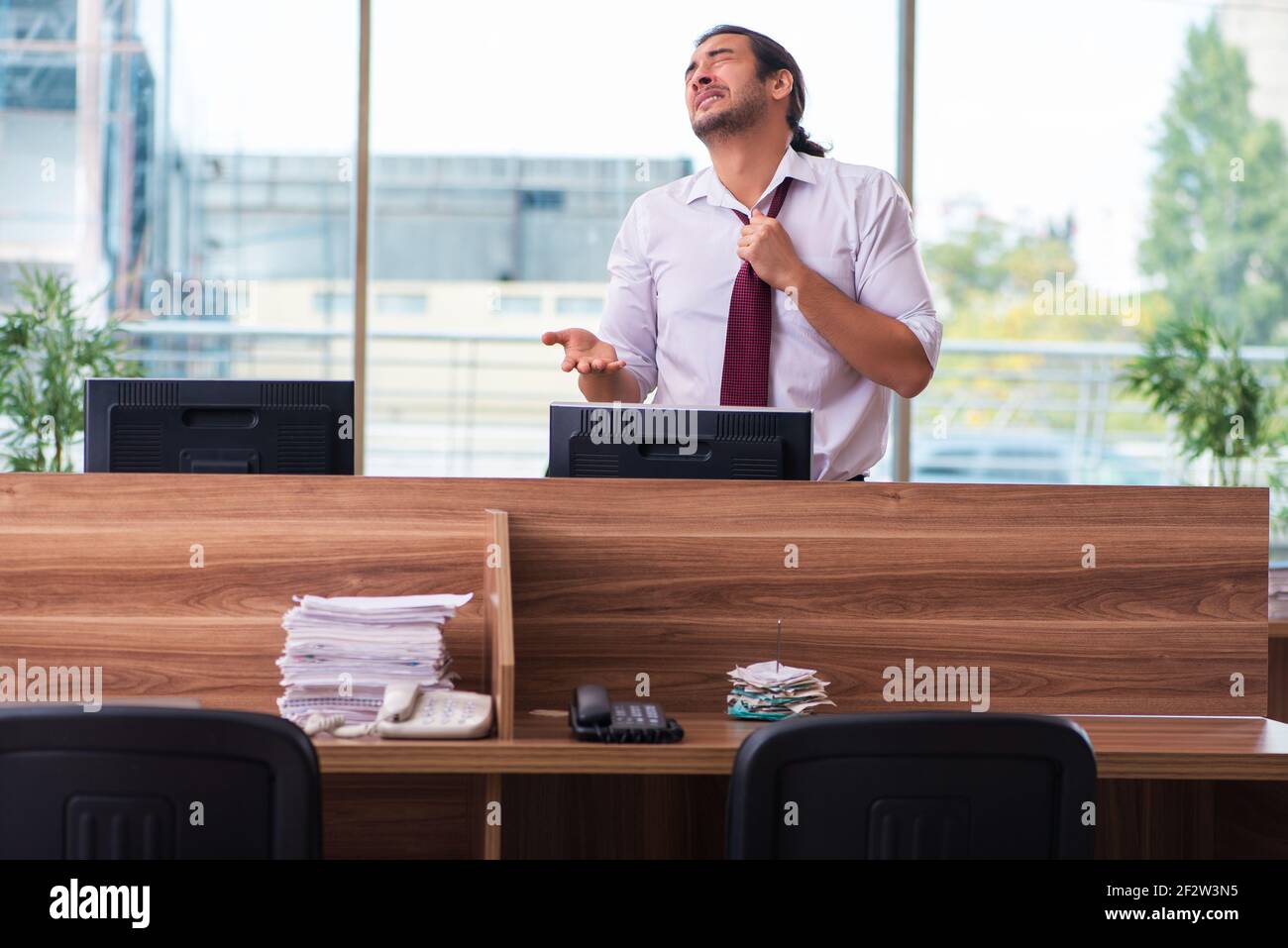 Young employee and too many work in the office Stock Photo - Alamy