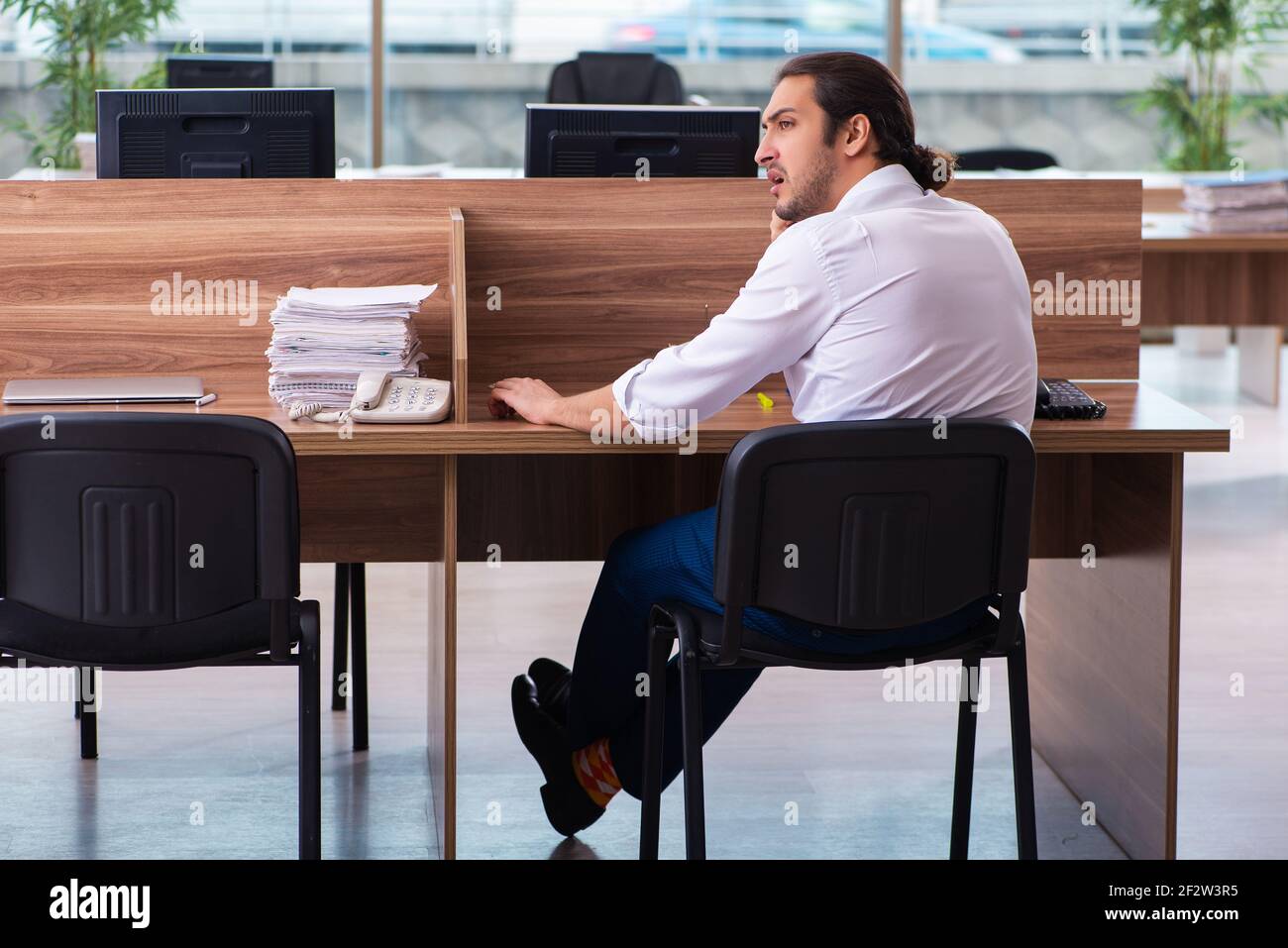 Young employee and too many work in the office Stock Photo - Alamy