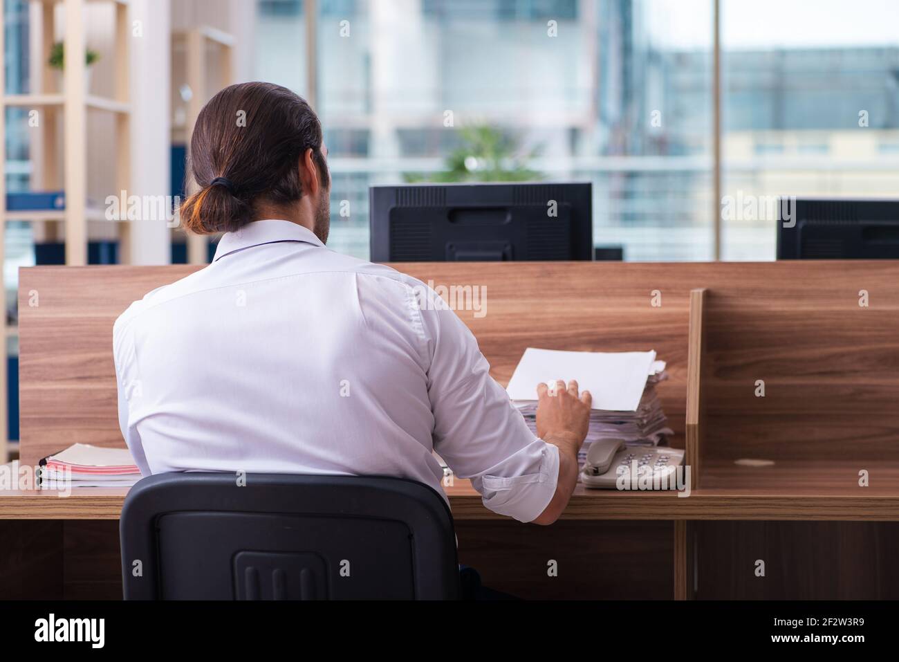Young employee and too many work in the office Stock Photo - Alamy