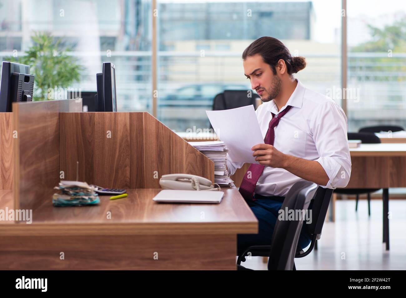 Young employee and too many work in the office Stock Photo - Alamy