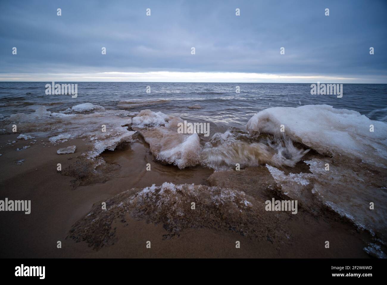 icy winter beach near the sea with frozen sand and ice blocks in the ...