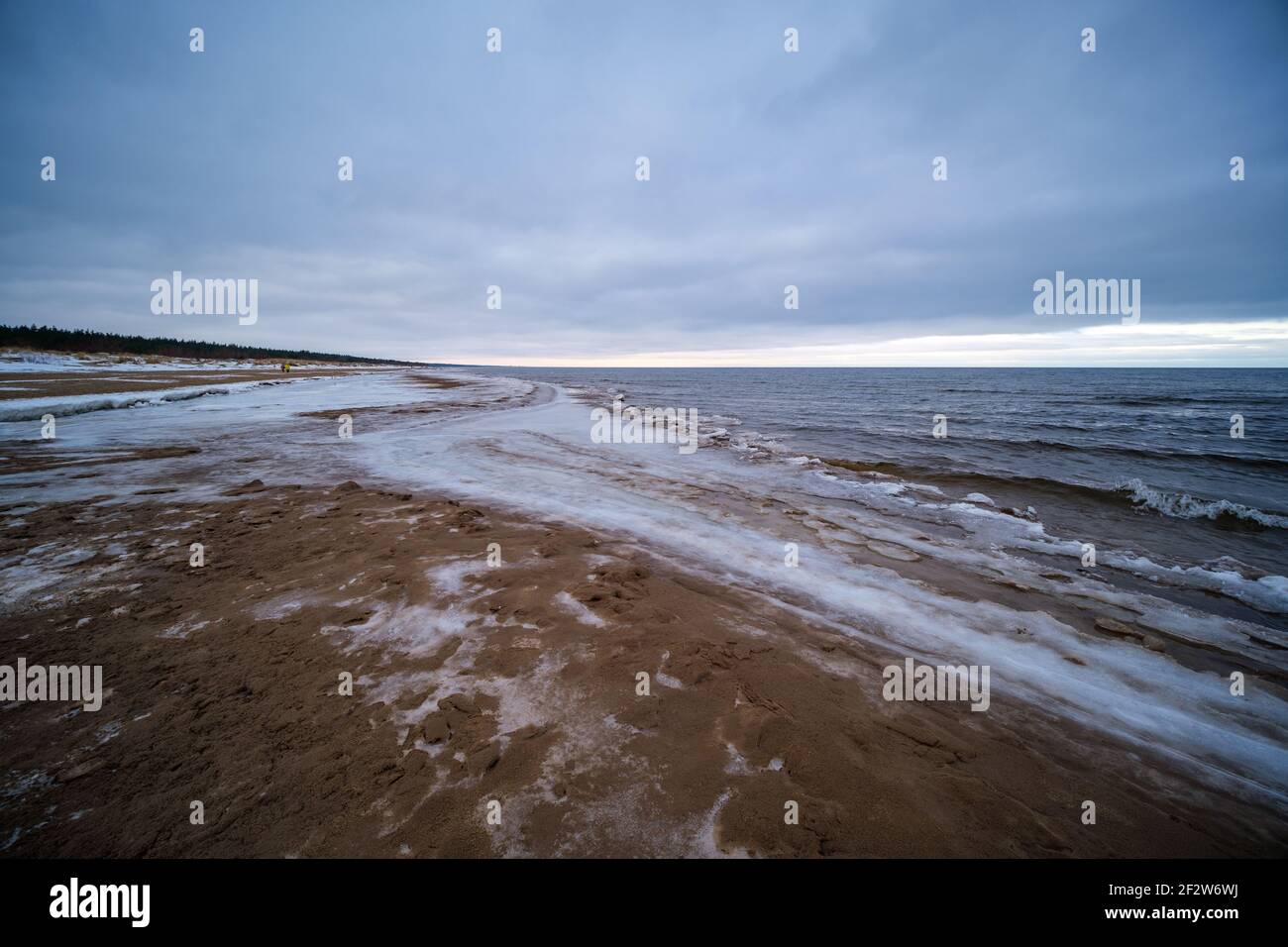 icy winter beach near the sea with frozen sand and ice blocks in the ...