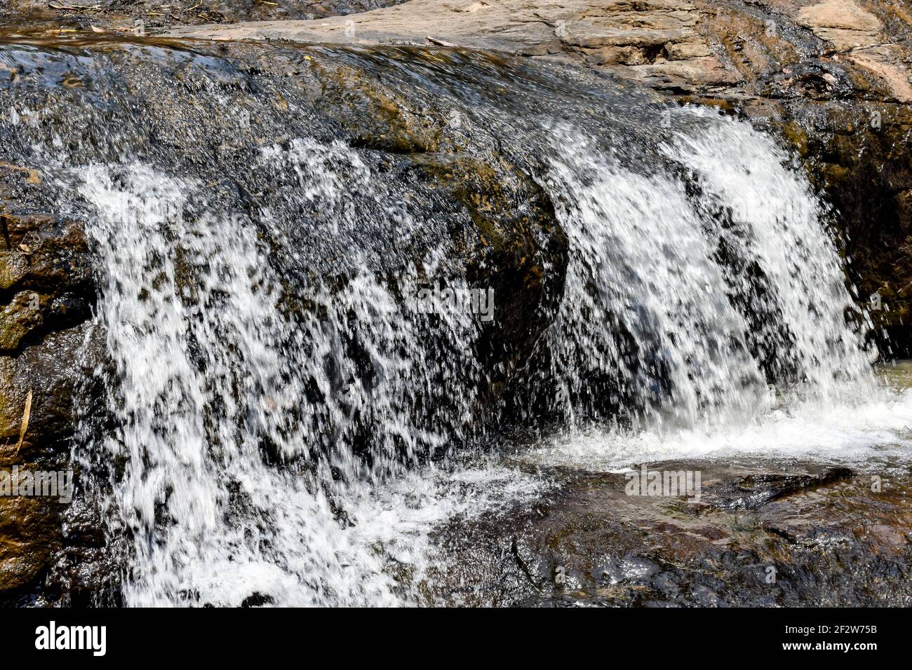 awesome view of waterfall passing through a mountain big rock near by ...