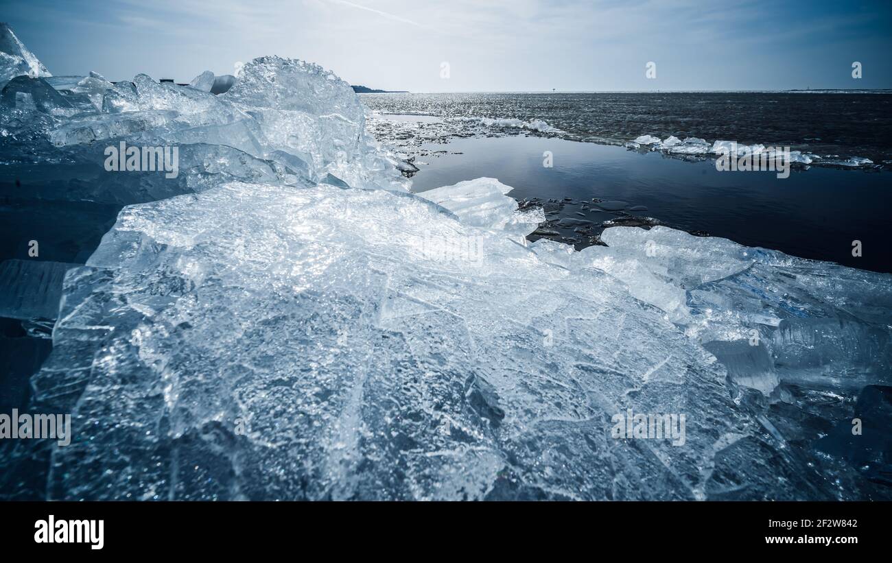 Ice floe breaking up against shore with sea ice during freezing winter ...