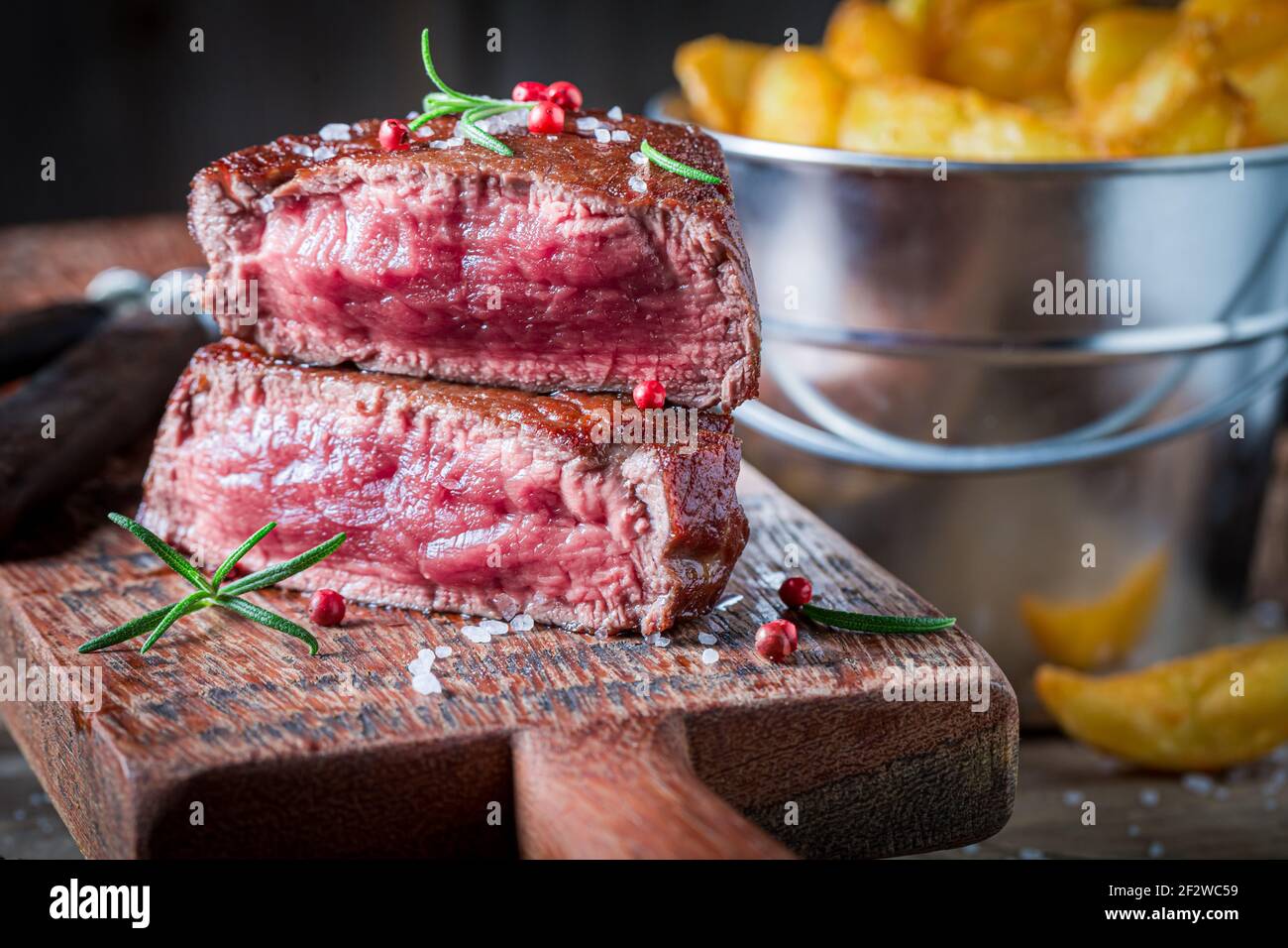 Medium-rare steak and chips with salt and rosemary. American cuisine ...