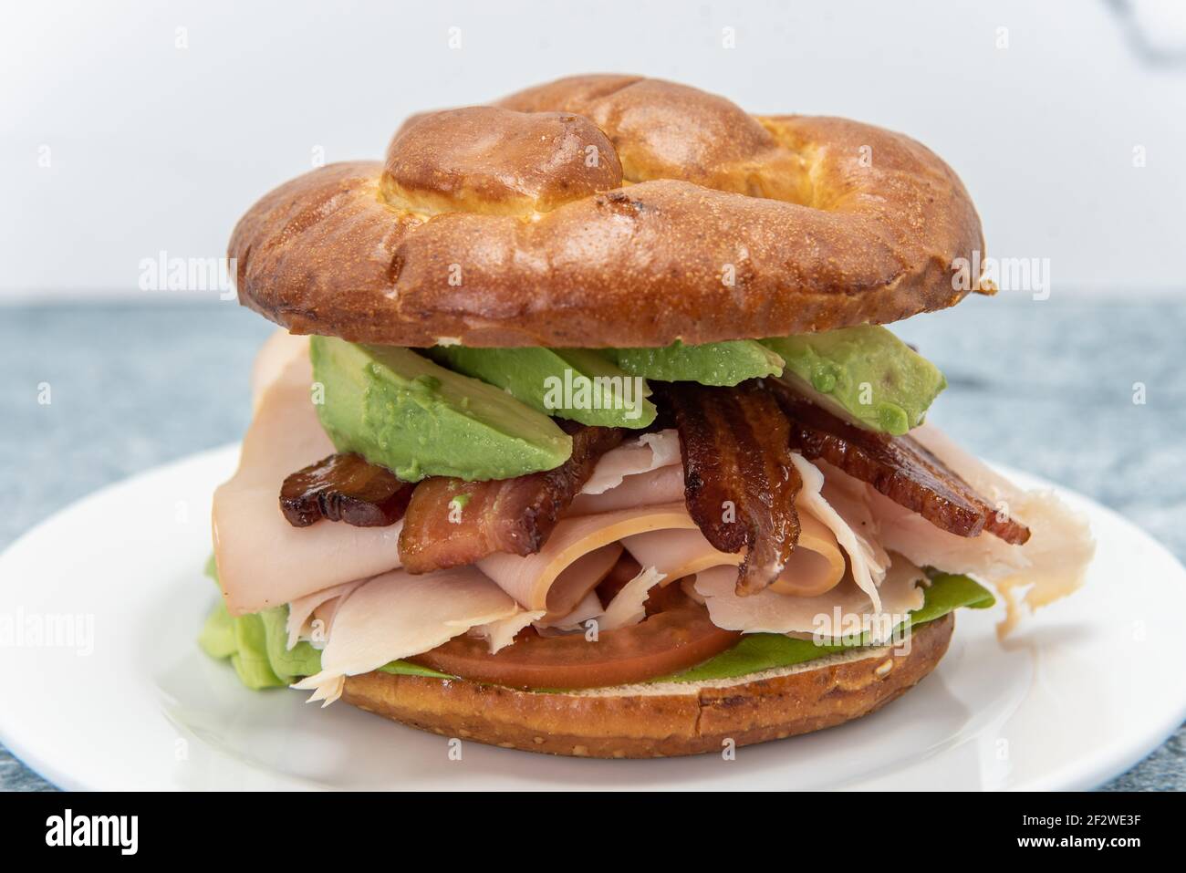 Unique chicken club sandwich served on a pretzel bun and loaded with ...