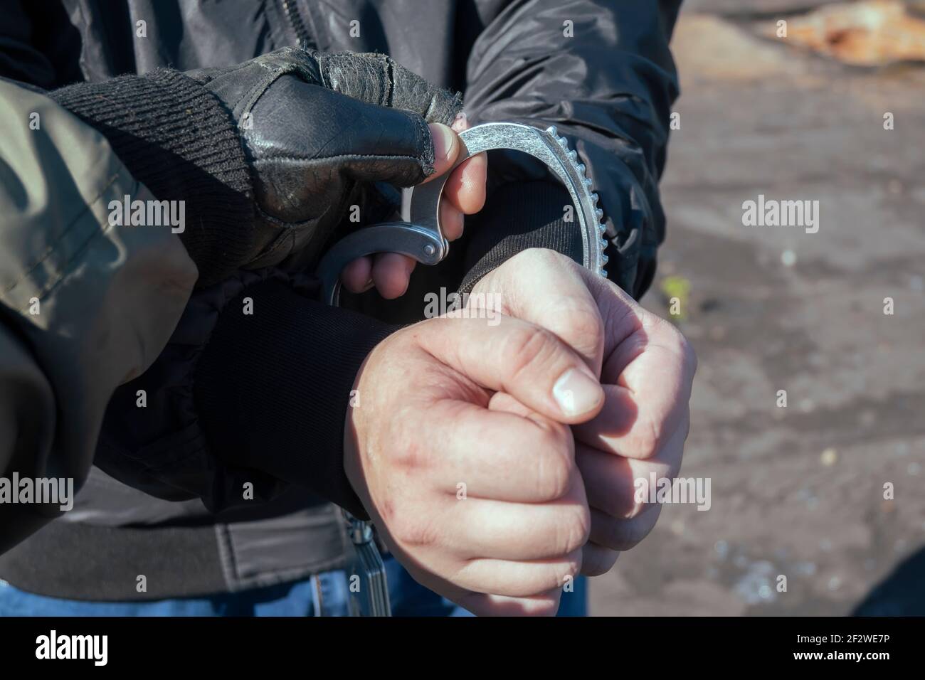 the hand of a special forces soldier puts handcuffs on the hands of a ...