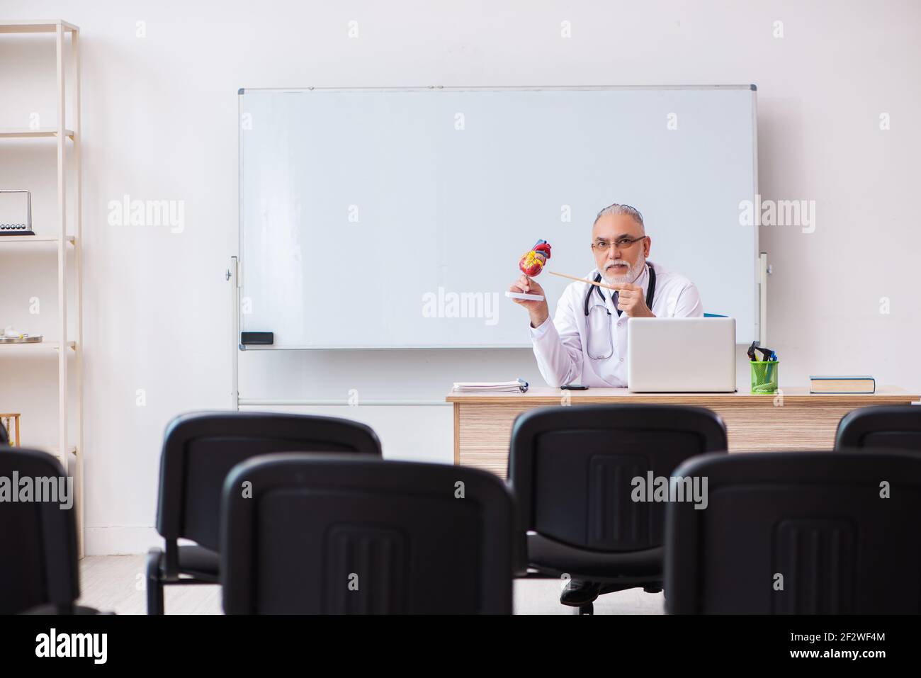 Old doctor lecturer in the classroom during pandemic Stock Photo - Alamy