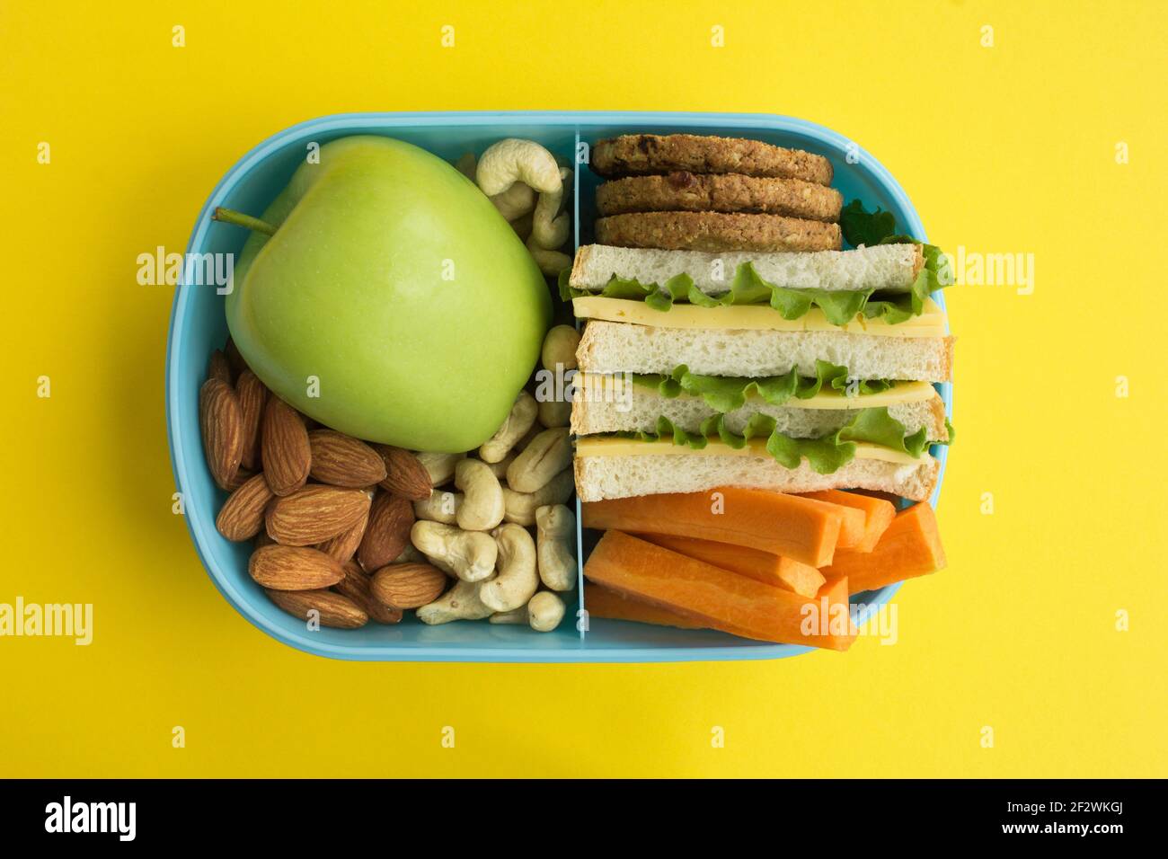 Lunch in the blue box in the center of the yellow background. Top view ...