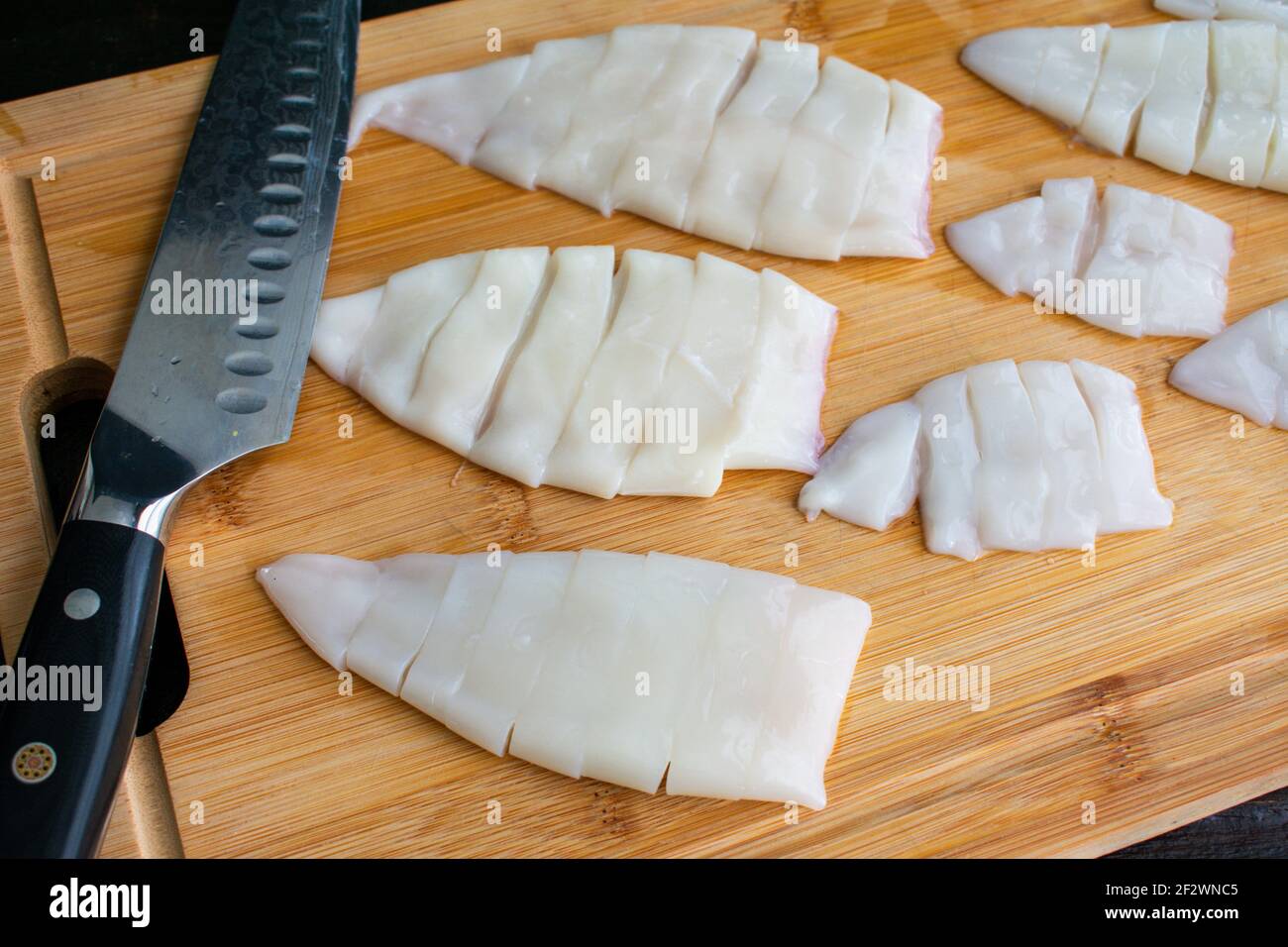 Sliced Squid Tubes on a Bamboo Cutting Board: Cleaned squid tubes being ...