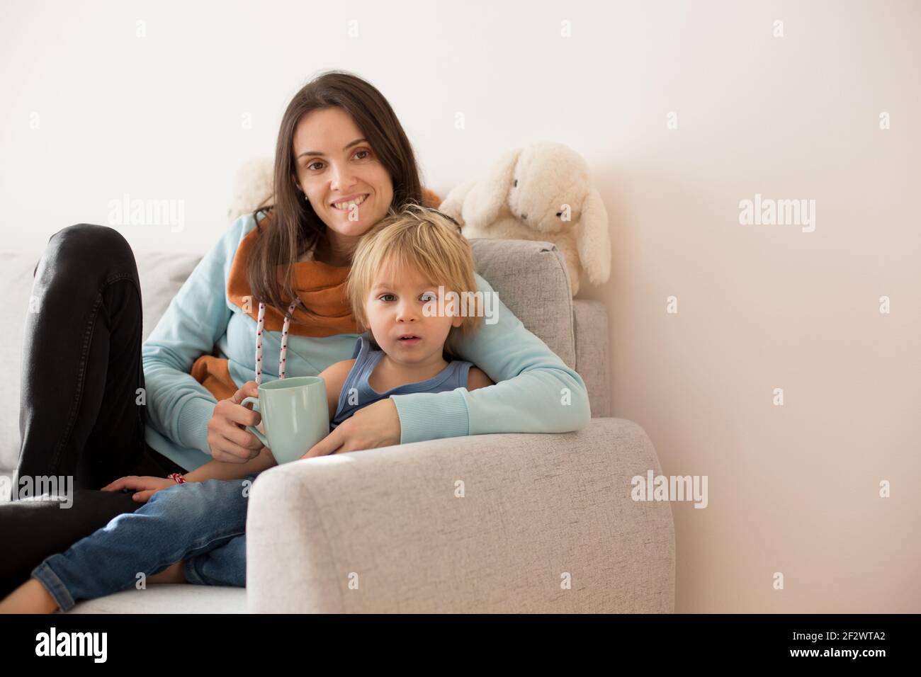 Mother and toddler child, hanging upside down from a couch at home ... Mother and toddler child, hanging upside down from a couch at home ...