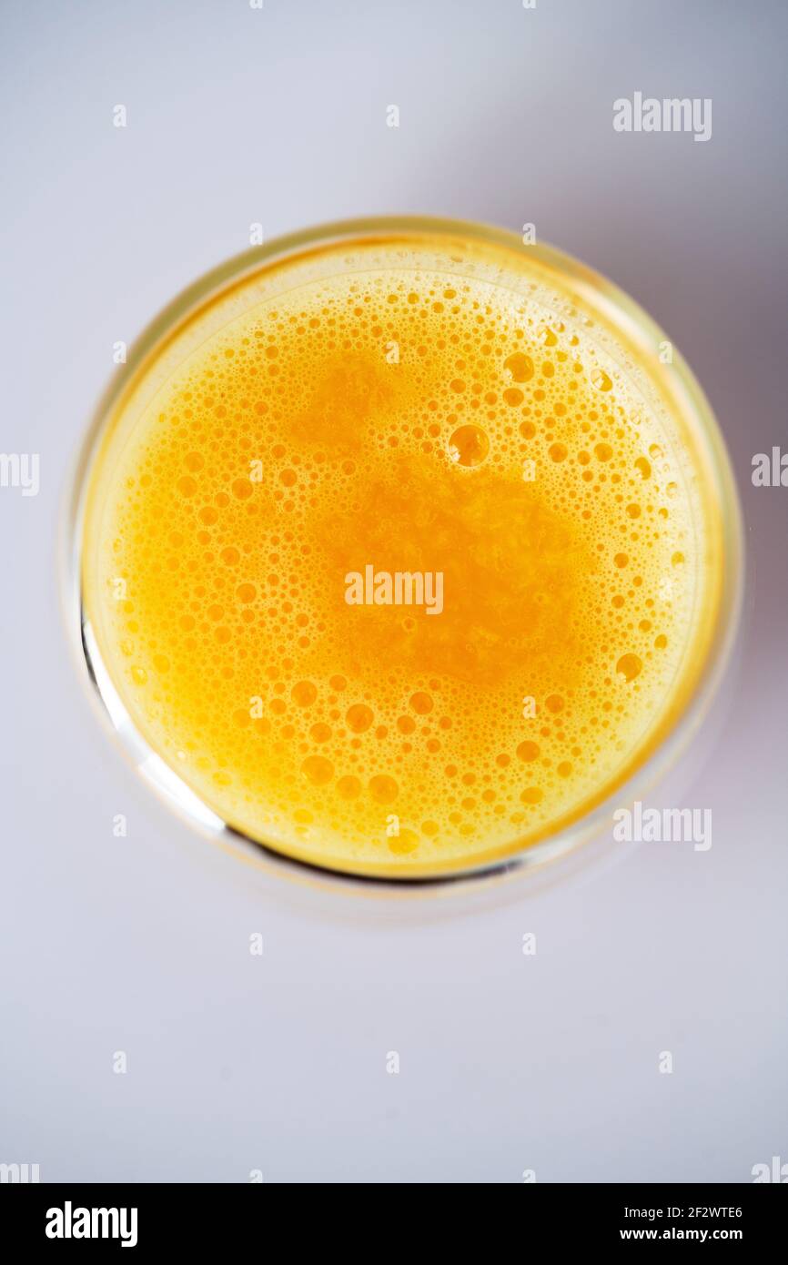 Healthy orange citrus freshly squeezed fruit juice in glass on light grey background, breakfast ...