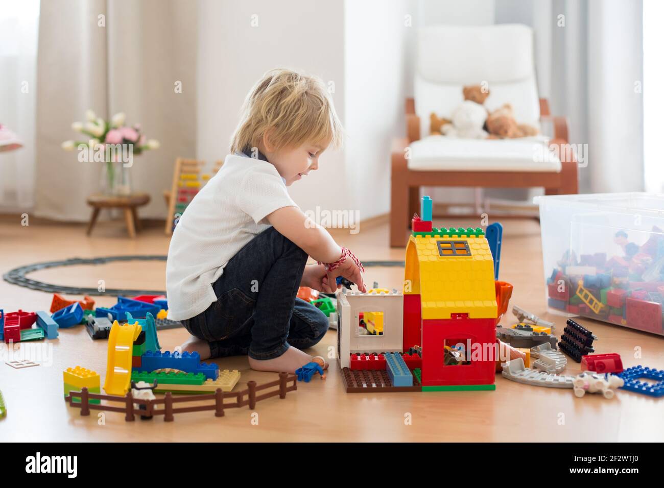 Cute child, playing with colorful toy blocks. Little boy building house ...
