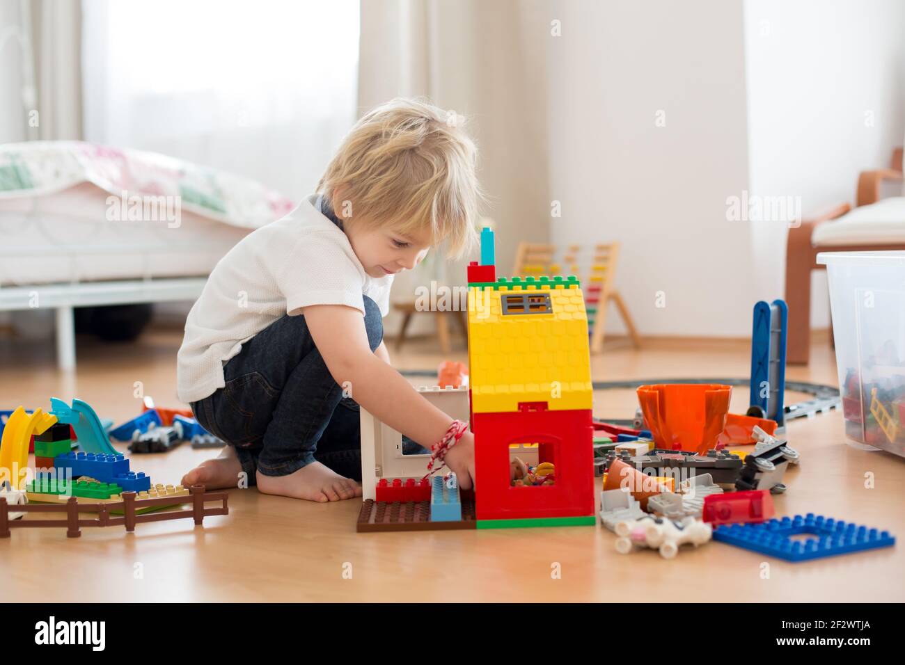 Cute child, playing with colorful toy blocks. Little boy building house ...