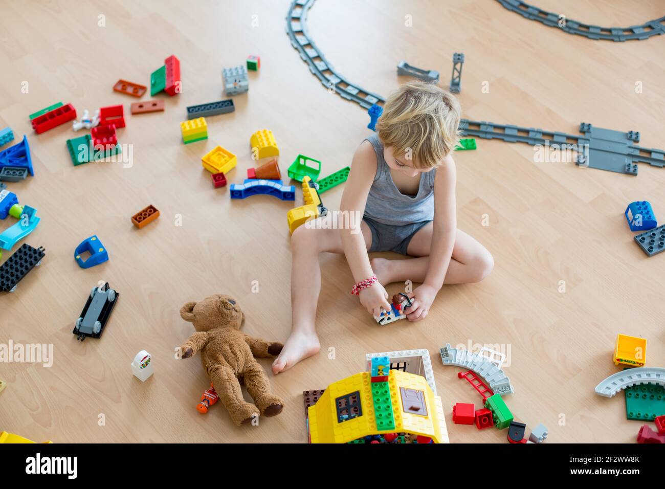 Cute child, playing with colorful toy blocks. Little boy building house ...