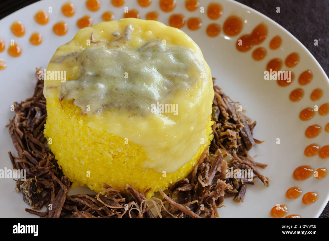 Corn couscous, with shredded sun meat and melted cheese on a white ...