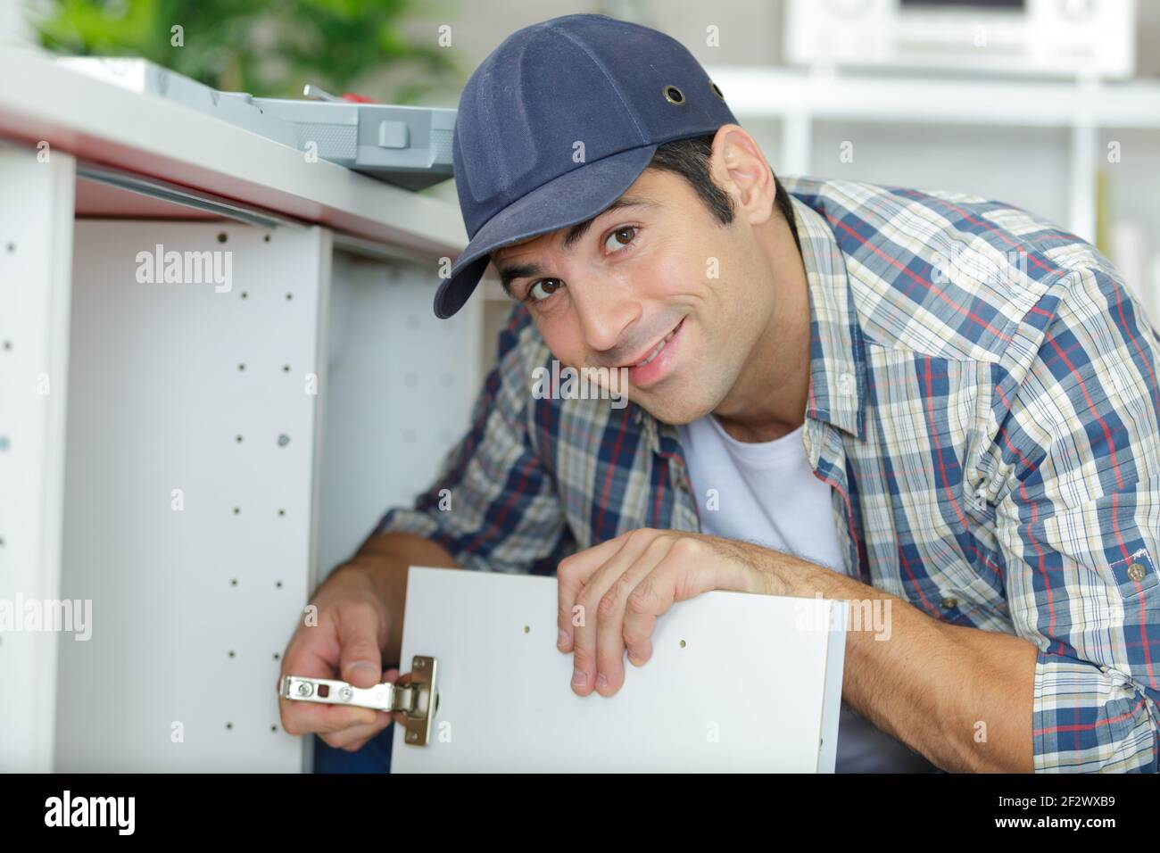 professional handyman installing cabinet door in the kitchen Stock ...