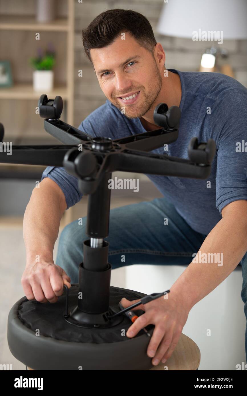 man fixing caster roller wheel of a wheel Stock Photo - Alamy