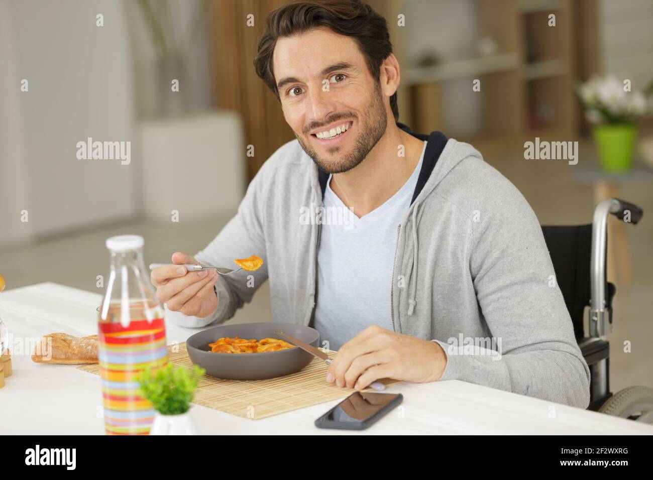 a delighted disabled man eating Stock Photo - Alamy
