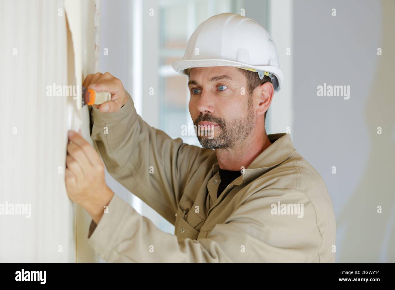 Plastering man wall helmet hi-res stock photography and images - Alamy
